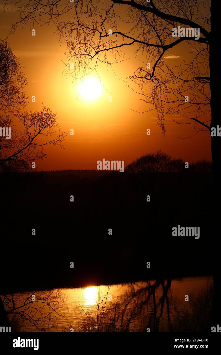 Vertical background with a bright red sunset over a pond Stock Photo ...