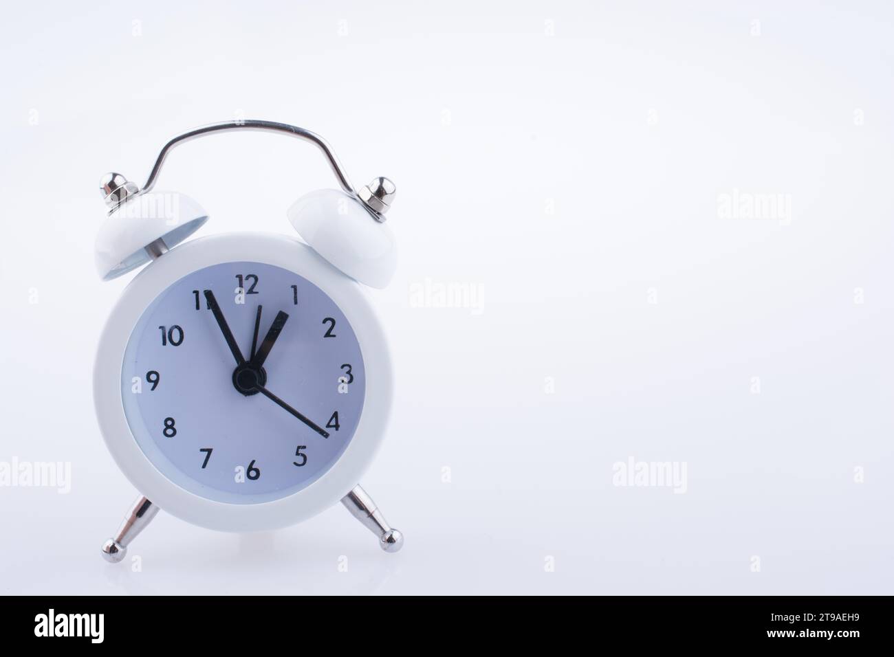 White color alarm clock on white background Stock Photo - Alamy