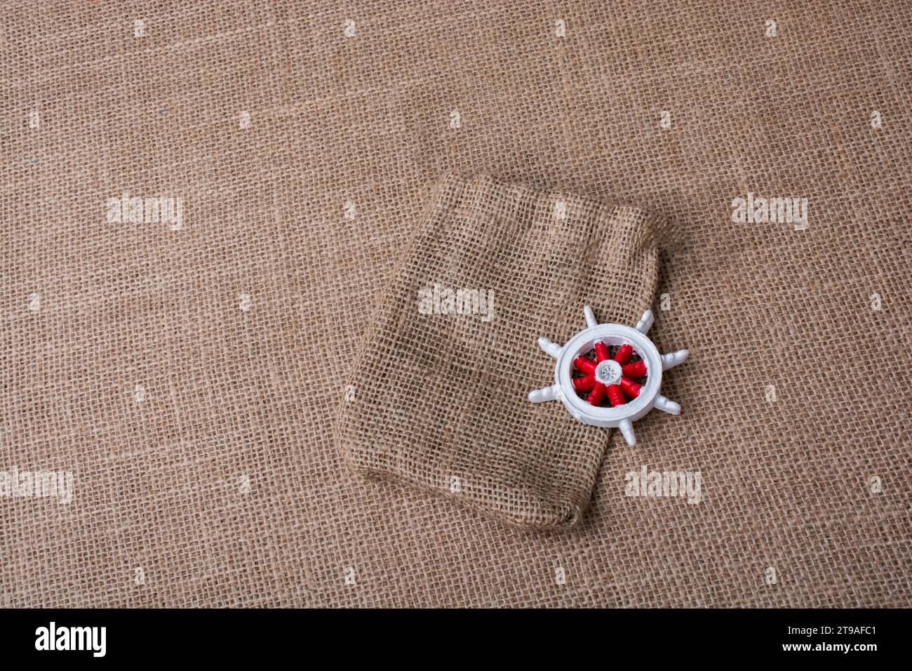 Steering wheel of a boat on a sack on canvas Stock Photo - Alamy