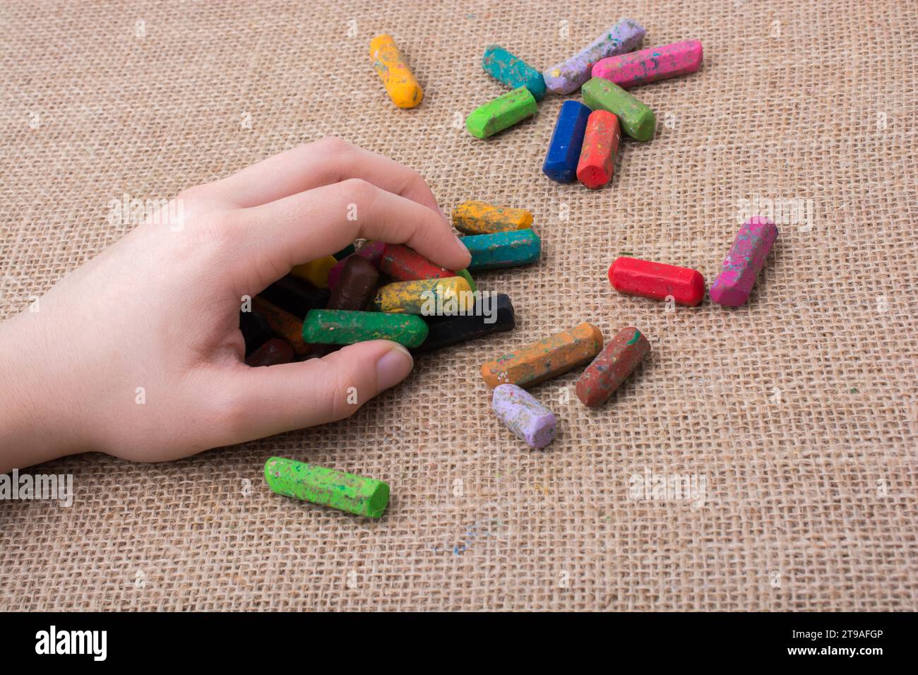 Used color crayons and a hand holding some Stock Photo - Alamy