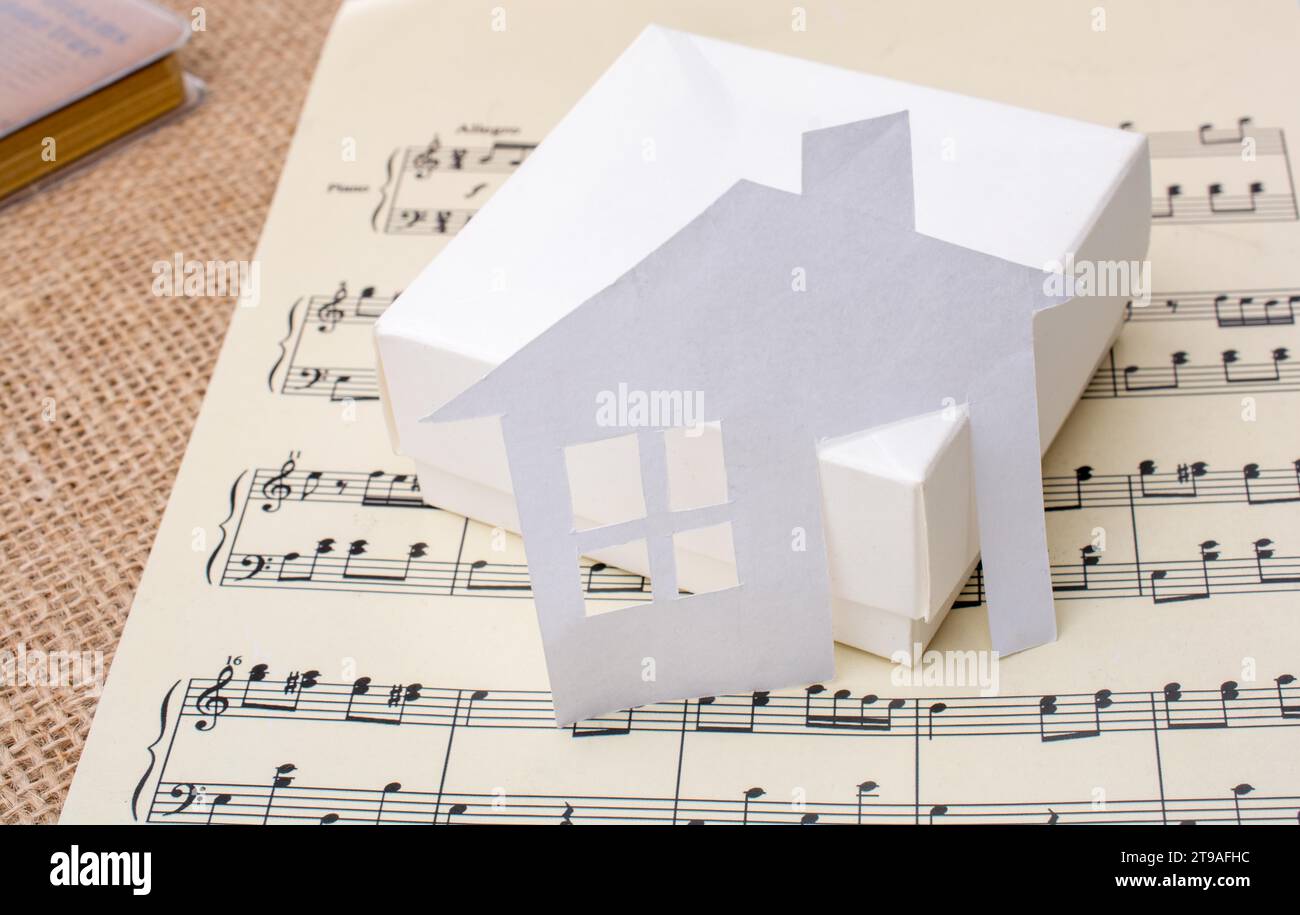 Paper house placed on a paper with musical notes Stock Photo - Alamy