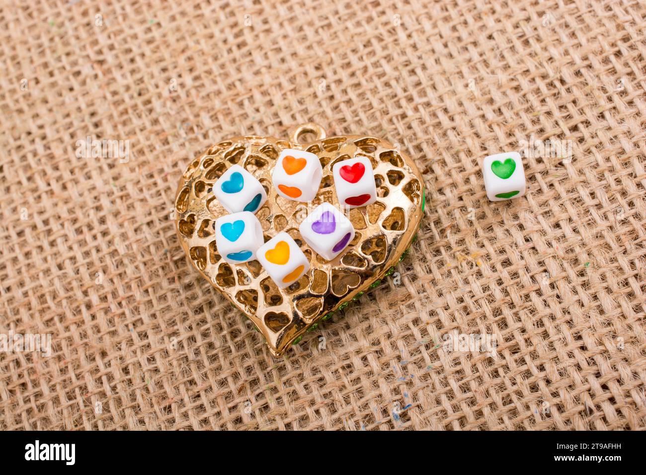 Heart cubes on Heart shaped gold color object Stock Photo - Alamy