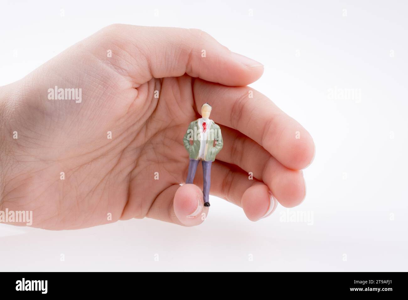 Hand holding a human figure on a white background Stock Photo - Alamy