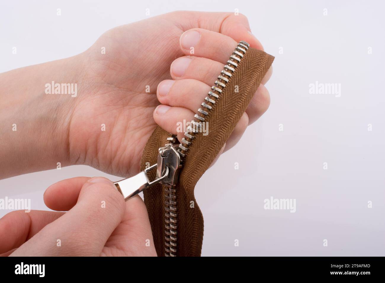 Hand holding color zipper on a white background Stock Photo - Alamy