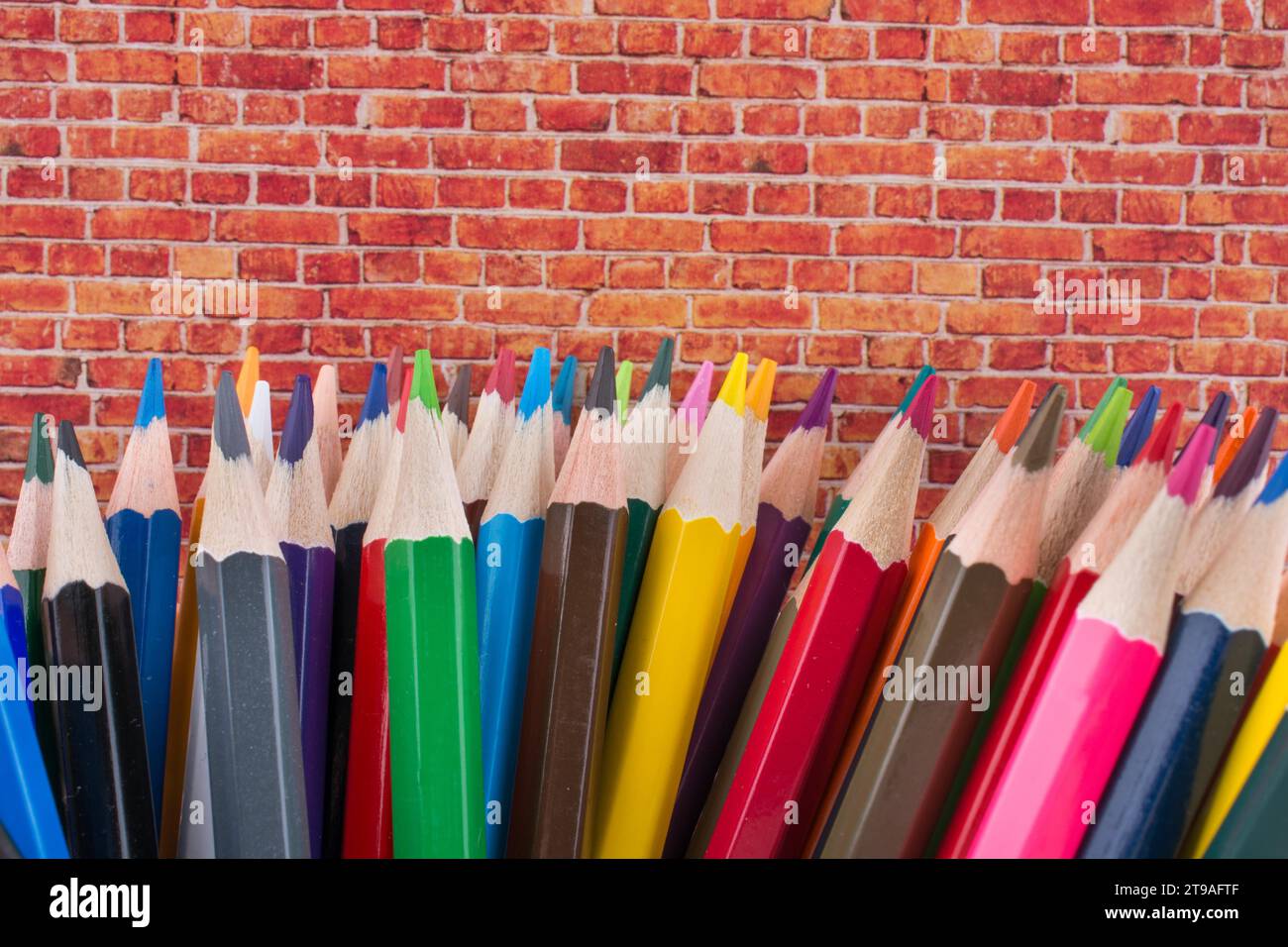 Color Pencils of various colors and brick wall on a white background ...