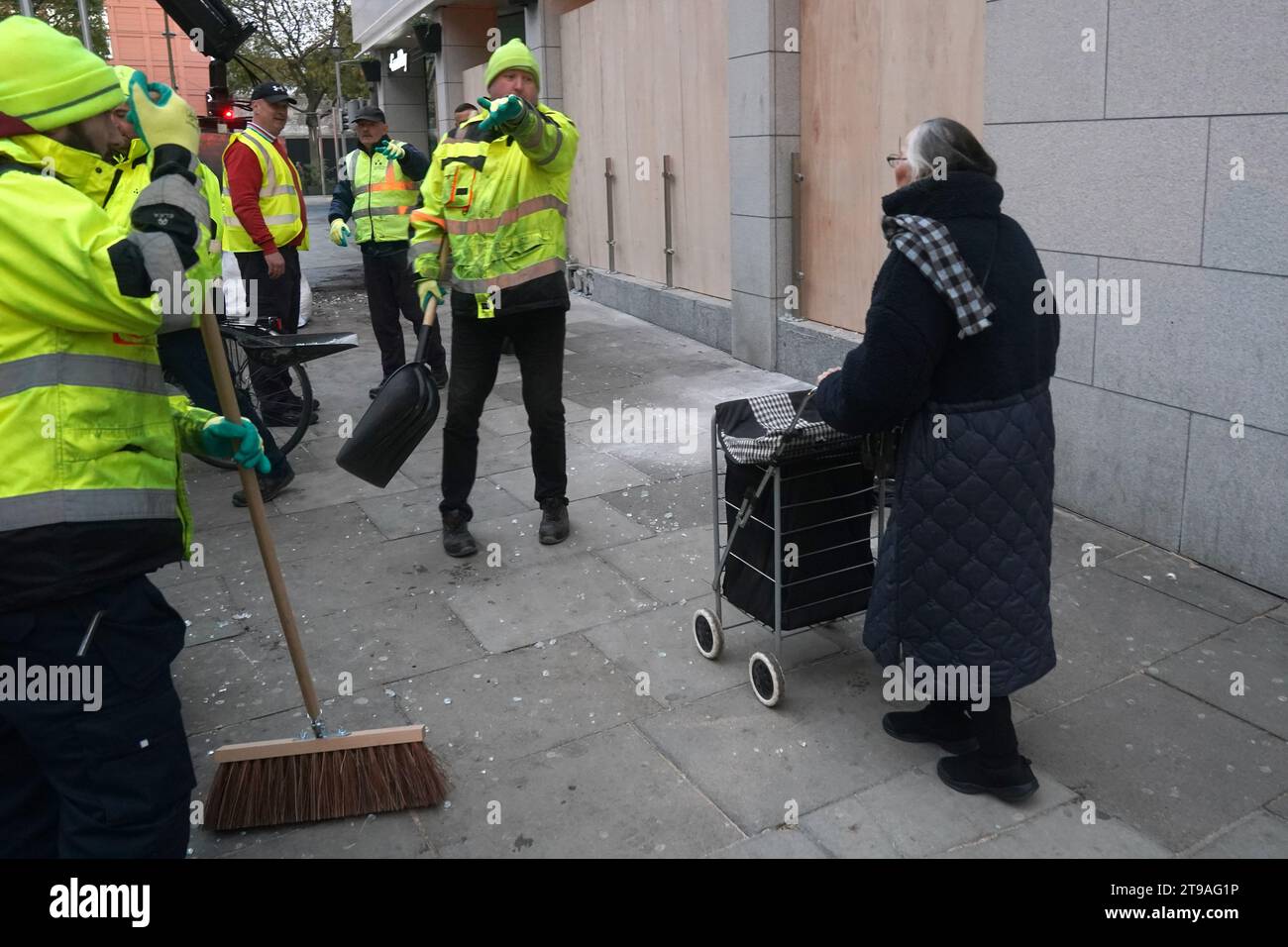Workers clean up the debris from broken windows of the Holiday Inn ...