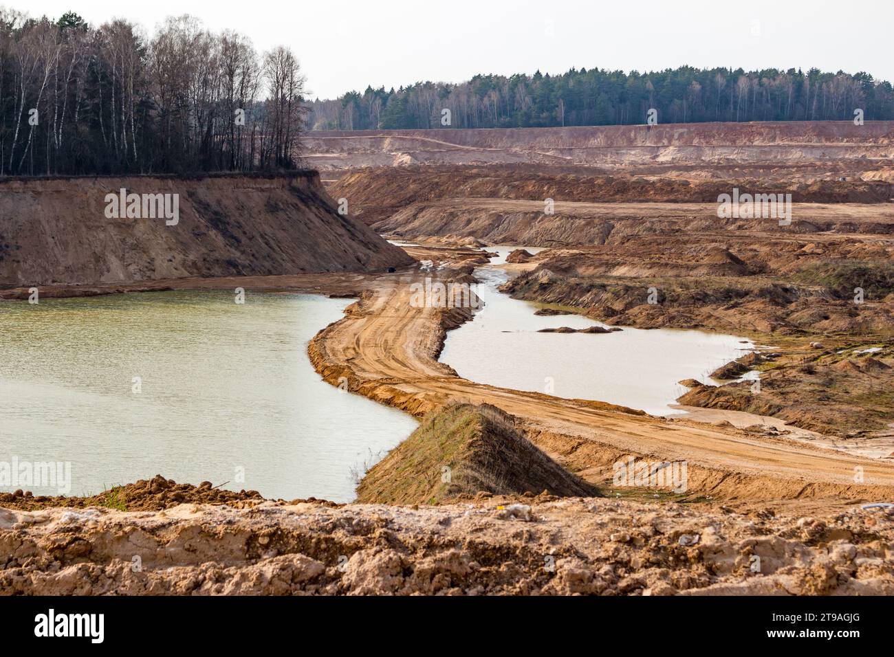 View of a large sand quarry area with a road embankment in the middle ...