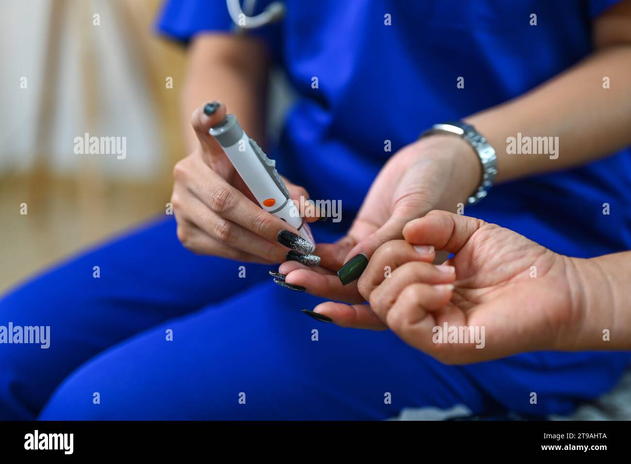 Nurse using lancelet on finger of diabetic patient to checking blood ...