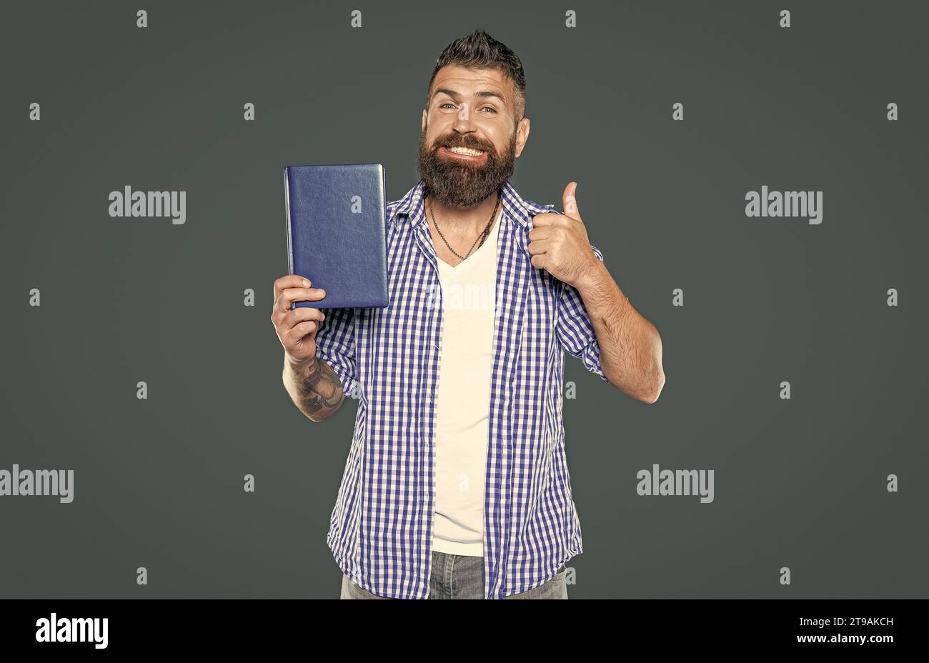 educational concept. cheerful bearded man recommend book on grey ...