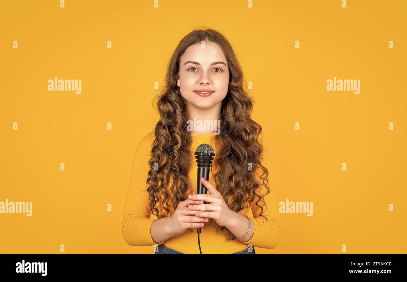 teen girl hold microphone on yellow background. Singer Stock Photo - Alamy