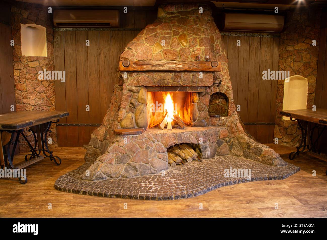 Old style stone fireplace. Wood burns in the fireplace with a blazing ...