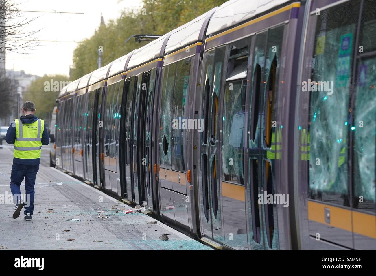 A Luas workers walks past a heavily damaged tram with smashed windows ...