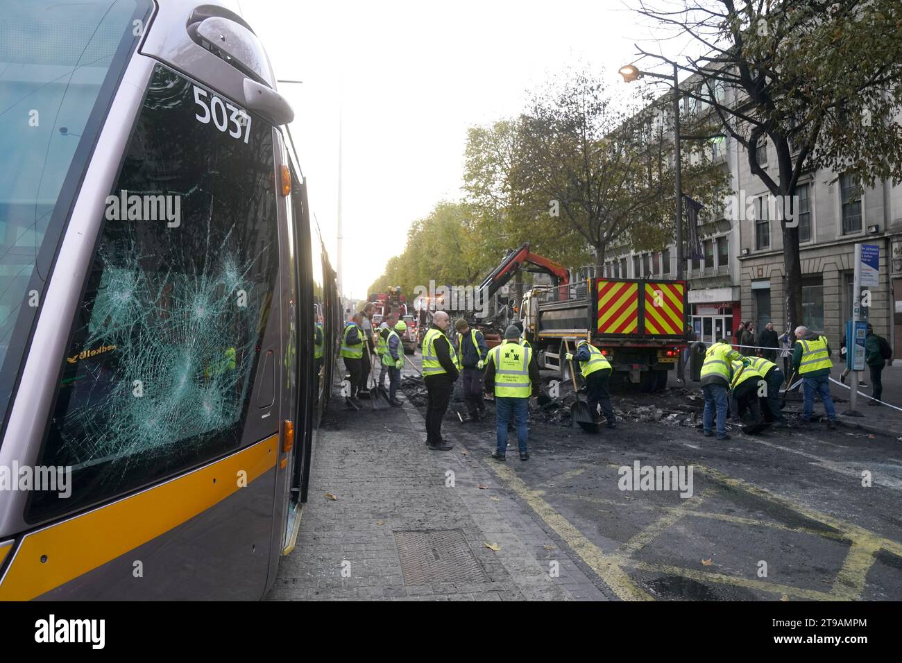 Workers clear debris next to a damaged Luas on O'Connell Street in ...
