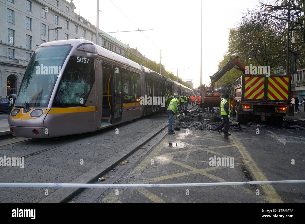Workers clear debris next to a damaged Luas on O'Connell Street in ...