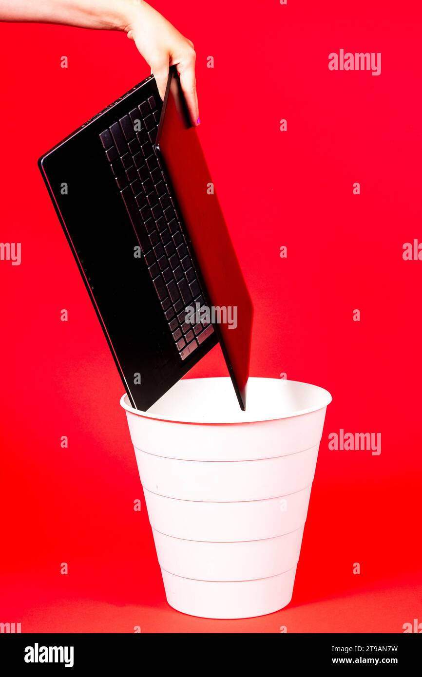 Black laptop in a trash bin on a red background isolated Stock Photo ...