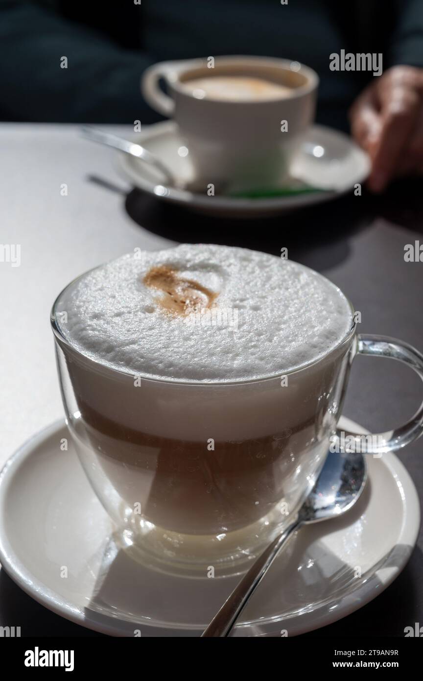 Drinking of tasty fresh brewed Italian caffe latte coffee with whipped ...