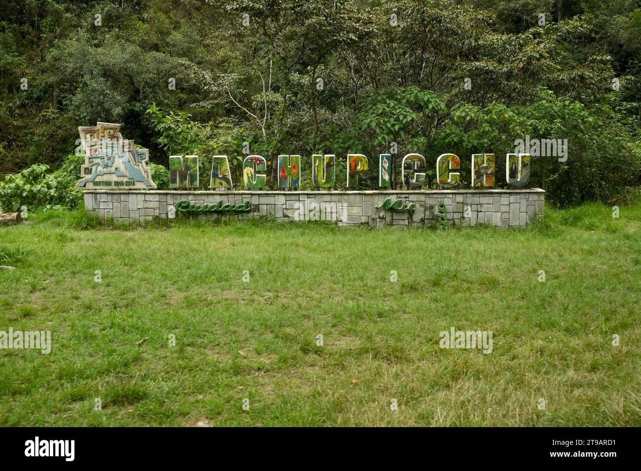 Machu Picchu stone sign by the railway line with trees behind. Aguas ...