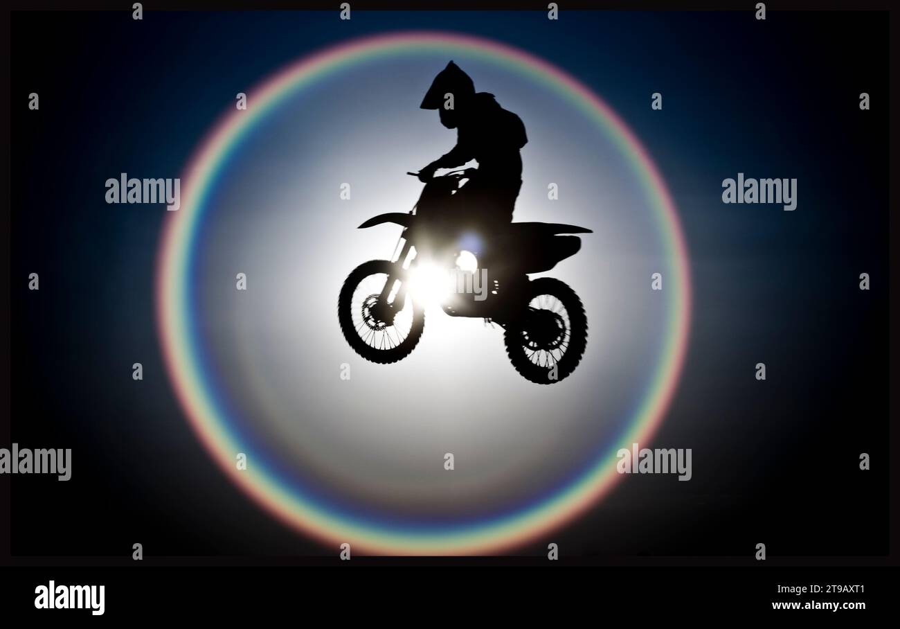 A motorbike rider eclipses the sun as he flies through the air in ...