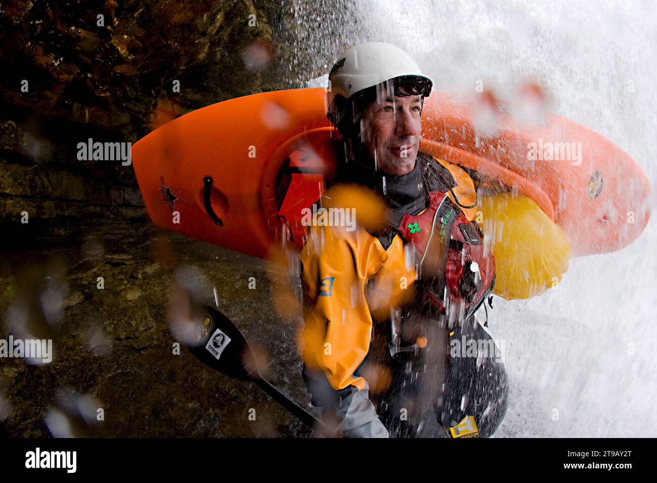 Attractive male kayaker standing underneath a waterfall Stock Photo - Alamy