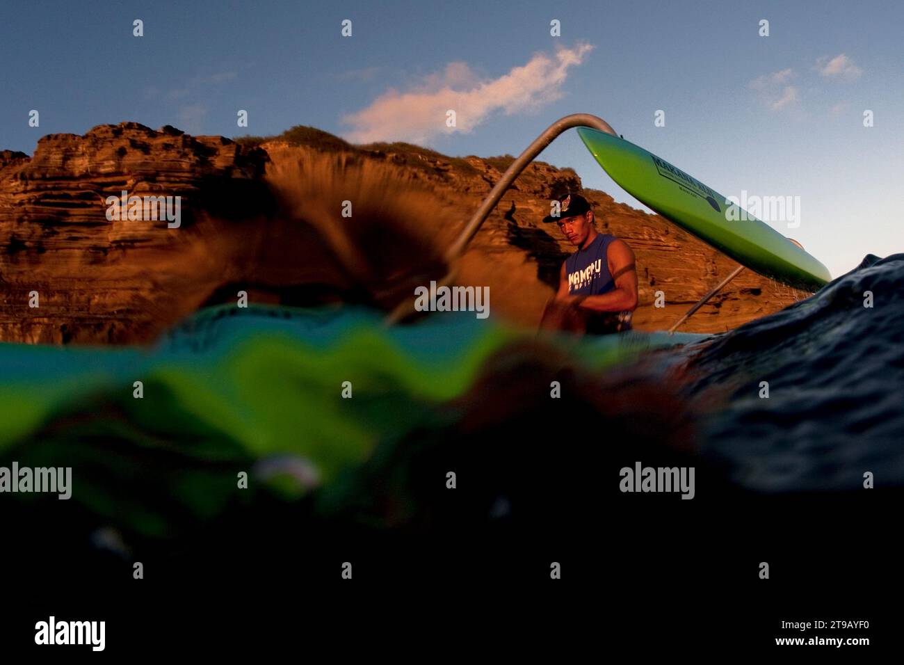 Low angle split level perspective of a man paddling a one man outrigger ...