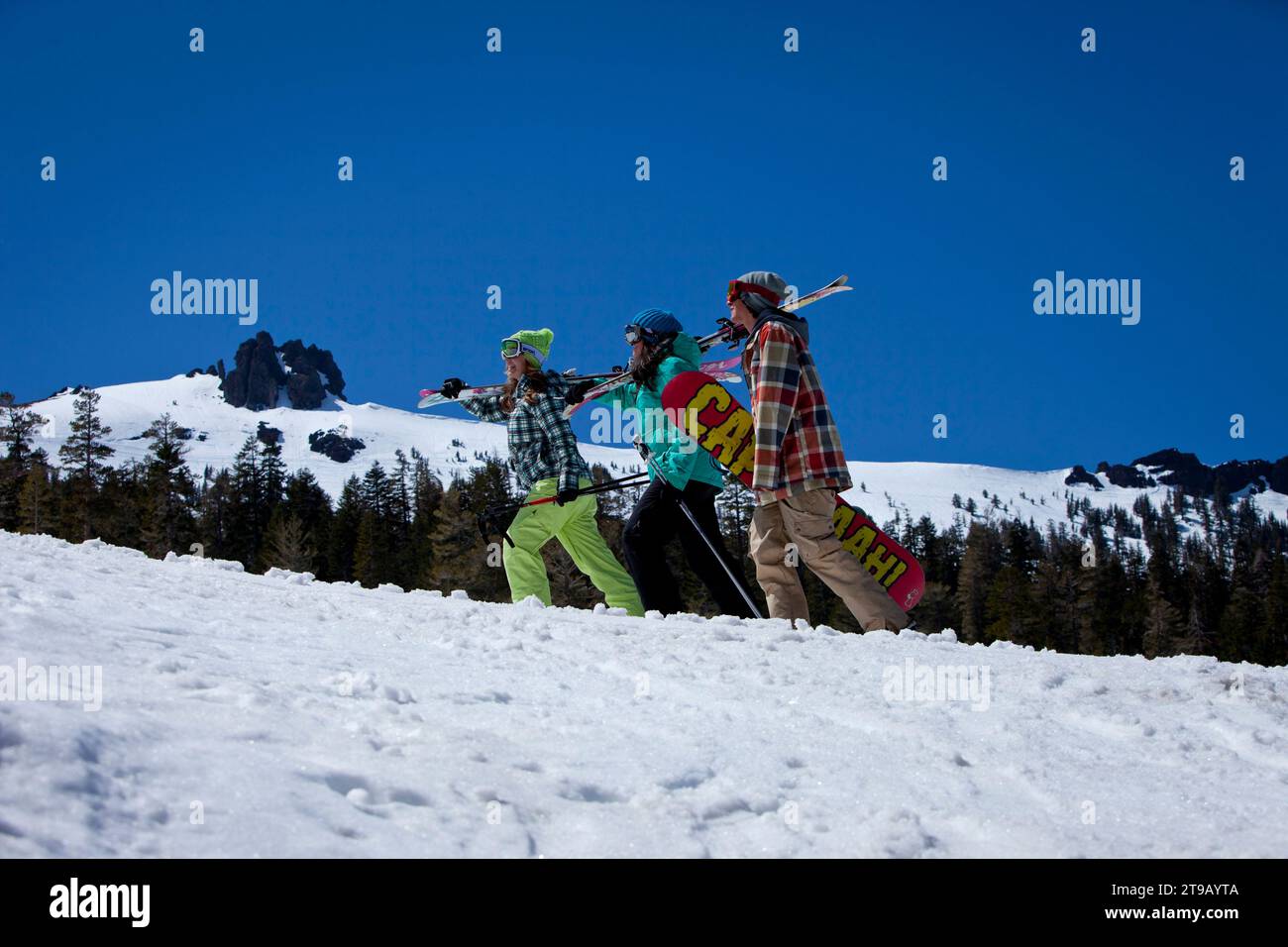 Three friends (one male and two females) hanging out with skis and a ...