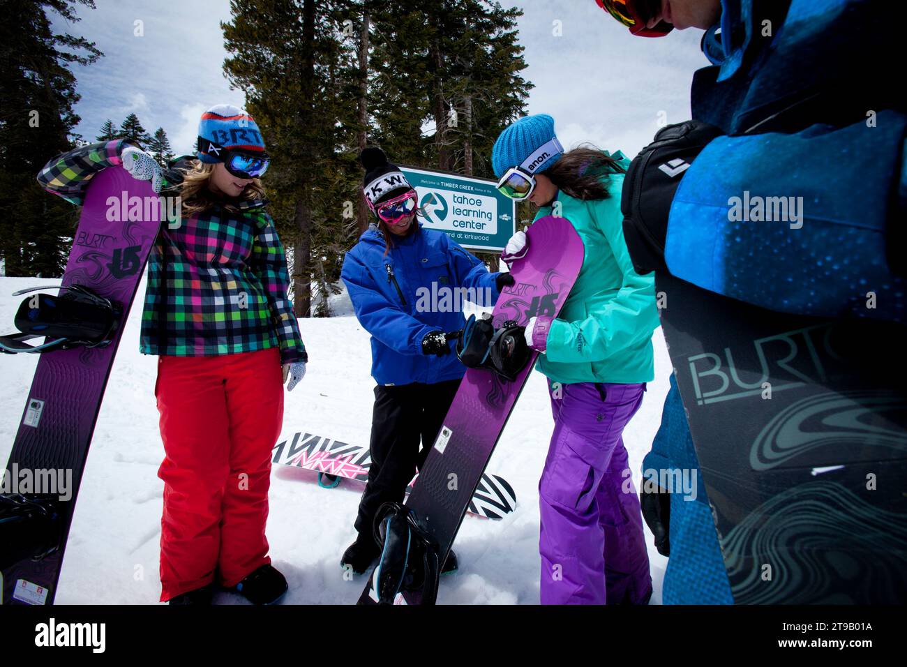 Three snowboard students listening to their snowboard instructor Stock ...