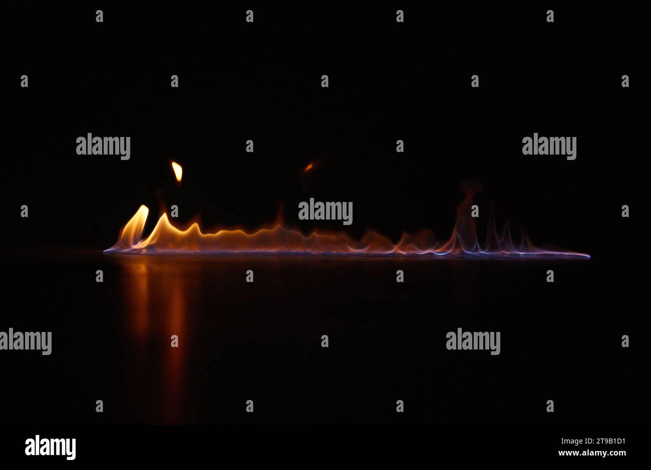 Flame, heat and gas fire with black background with sparks, smoke and ...