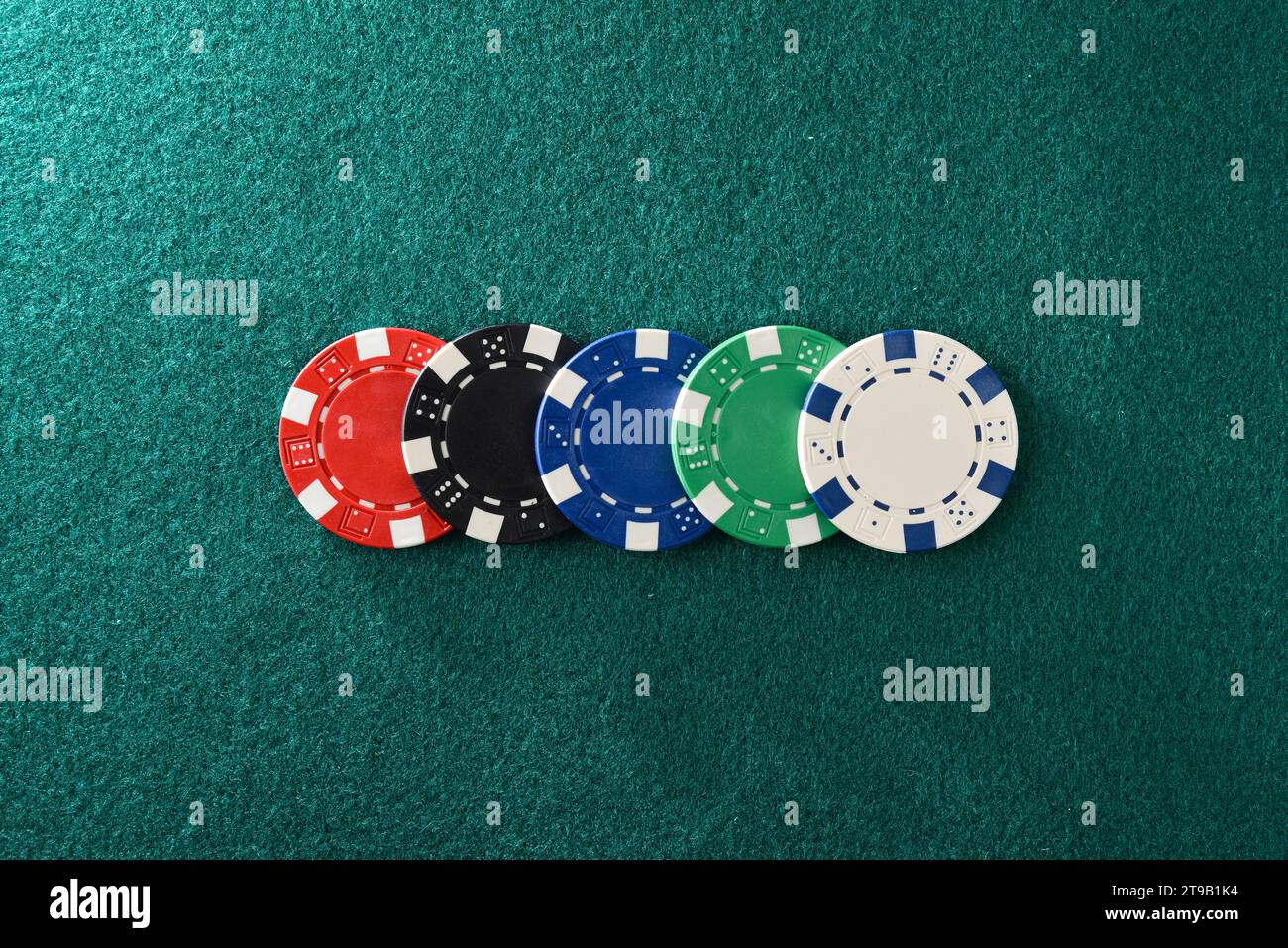 Casino background with detail of five different colored plastic chips ...