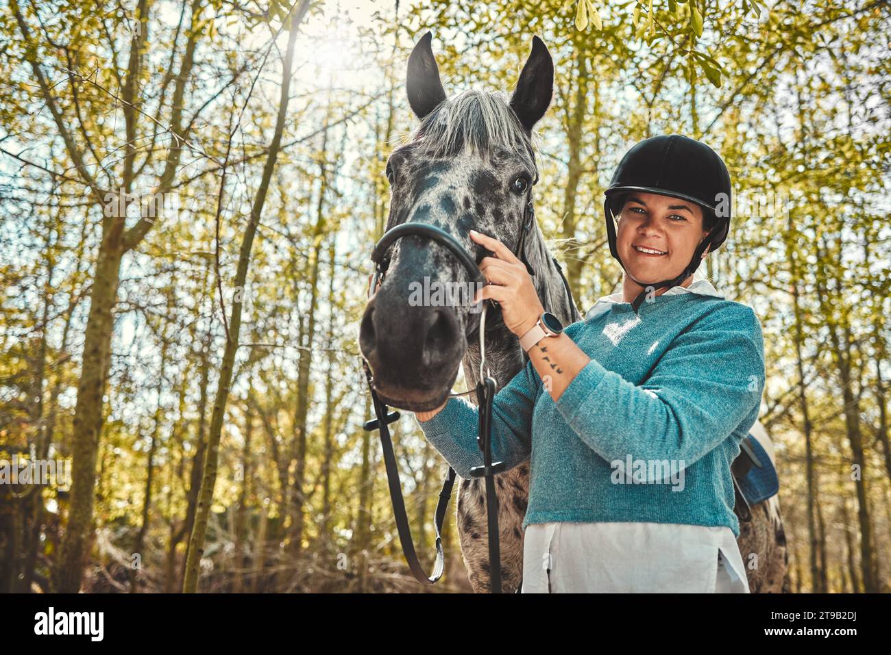 Portrait of woman with horse in woods, smile and pride for competition ...