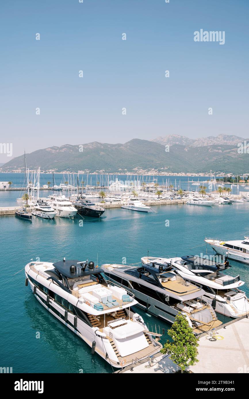 Row of double-decker yachts with sun loungers on the roof are moored at ...