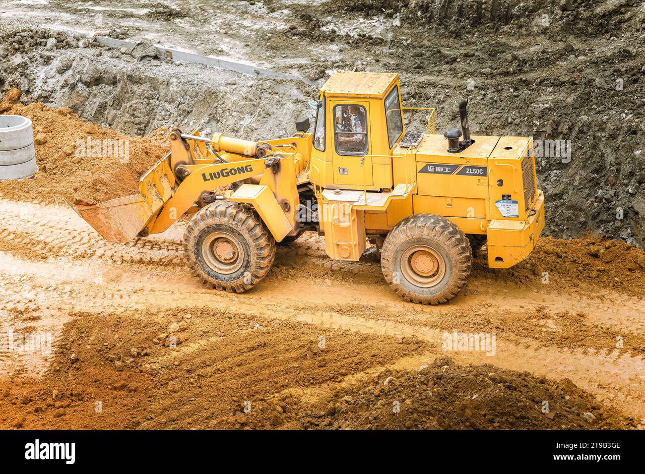 Excavator digging soil in the construction site Stock Photo - Alamy