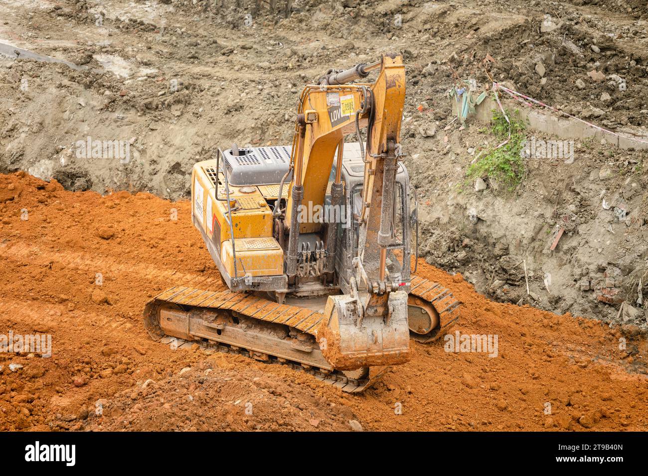 Excavator digging soil in the construction site Stock Photo - Alamy