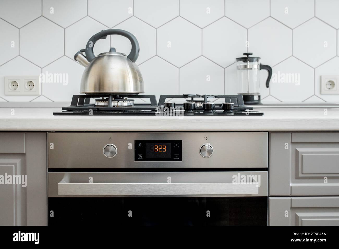 Built-in gas stove and oven in a modern kitchen with a kettle and ...