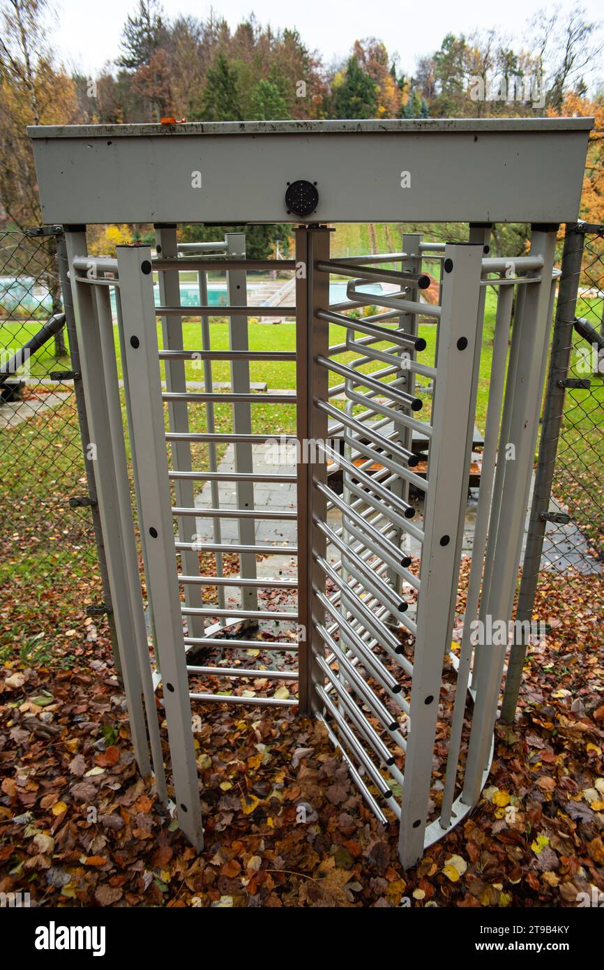 Revolving metal turnstiles secure acces gate entrance to a public park ...