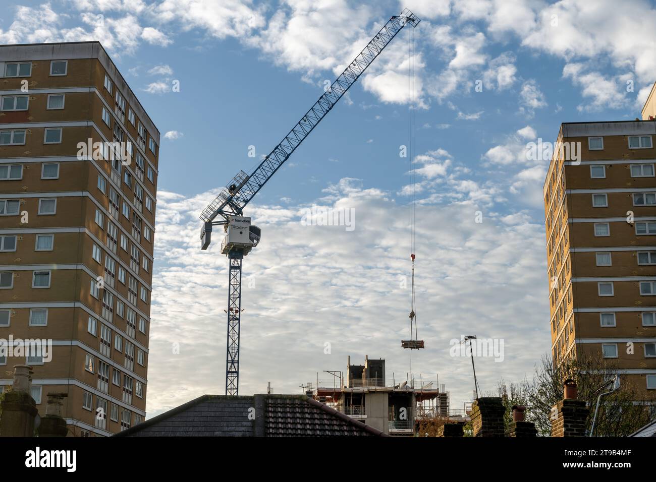 London. UK- 11.23.2023. A construction lifting crane carrying heavy ...