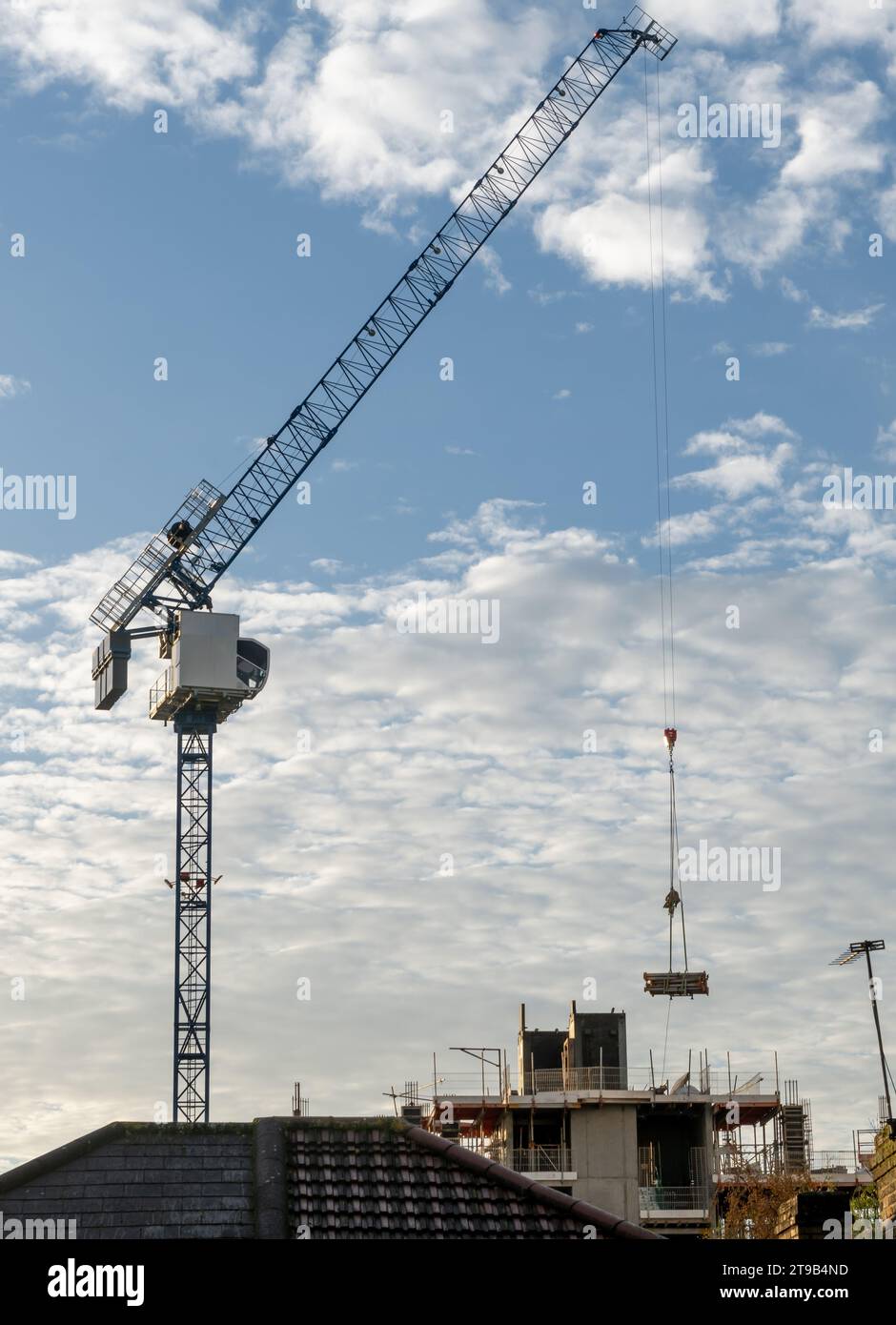 London. UK- 11.23.2023. A construction lifting crane carrying heavy ...