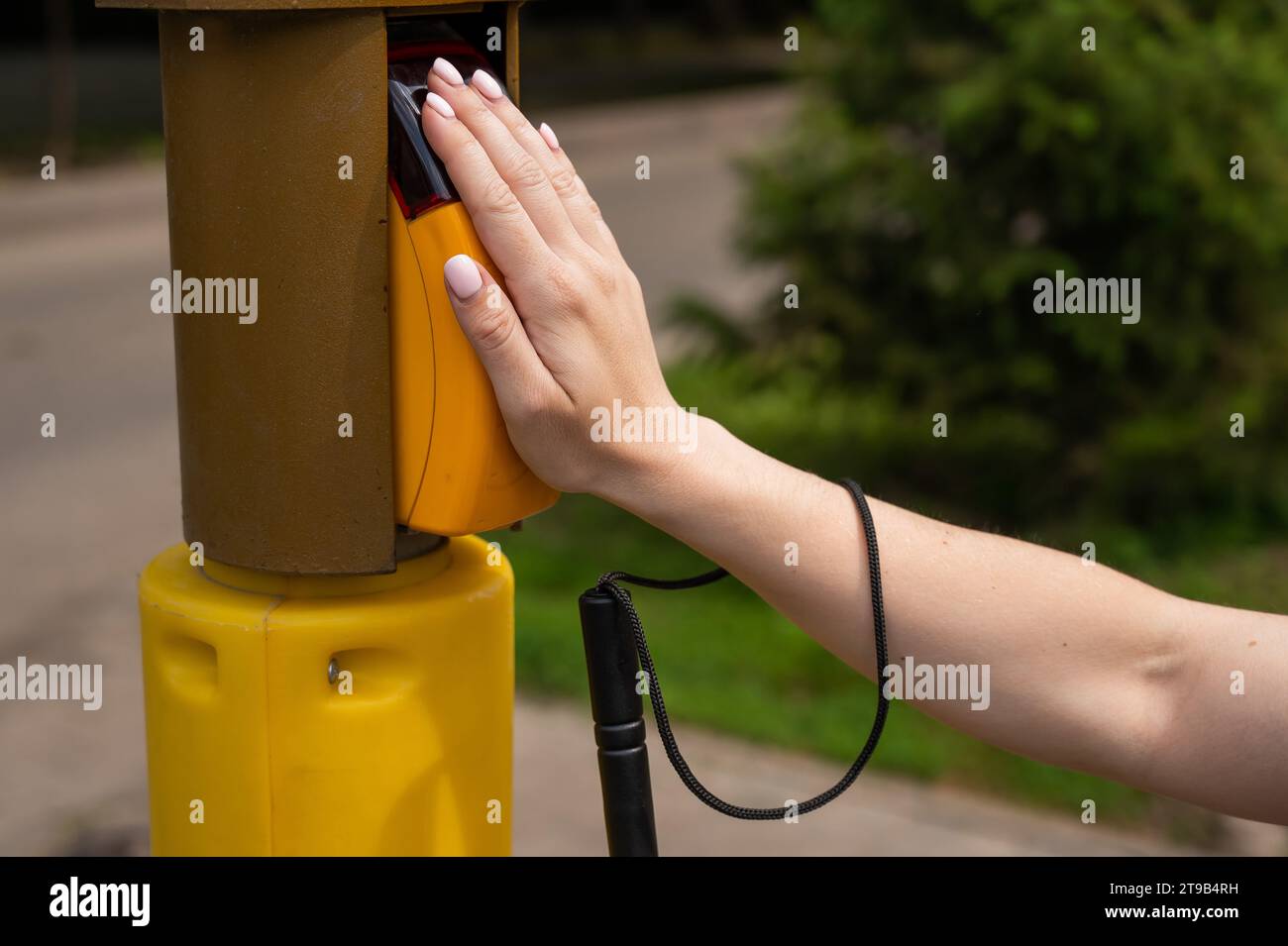 Close-up of a blind woman's hand pressing a button for a traffic light ...