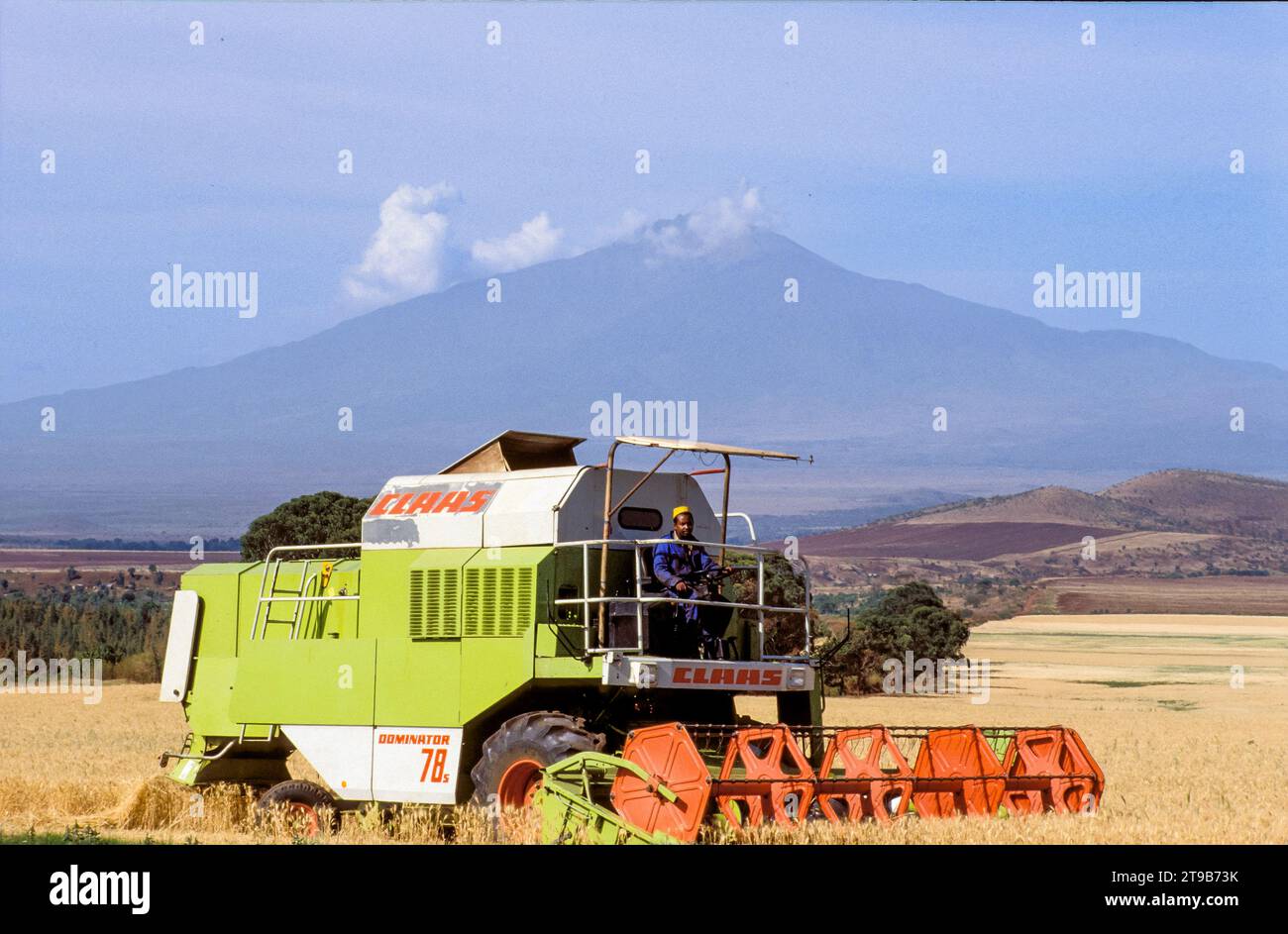 Tanzania, Moshi; A harvesting machine at work in a grain field. This ...