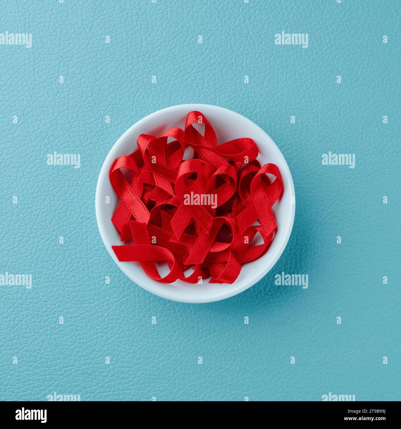 high angle view of a white ceramic bowl with some red awareness ribbons ...