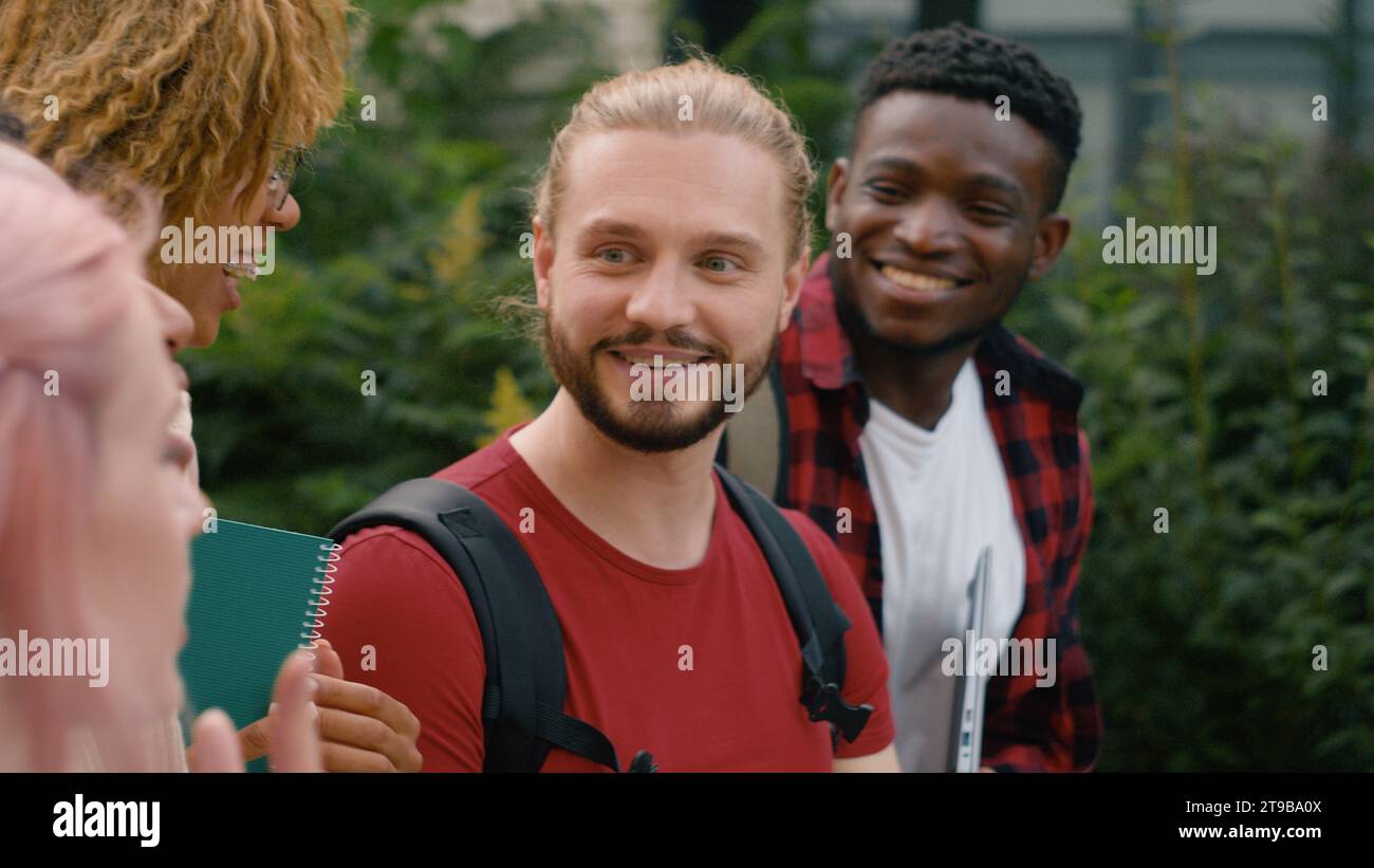 Closeup speaking smiling laughing five gen z diverse multiracial students boys girls talk walk ...
