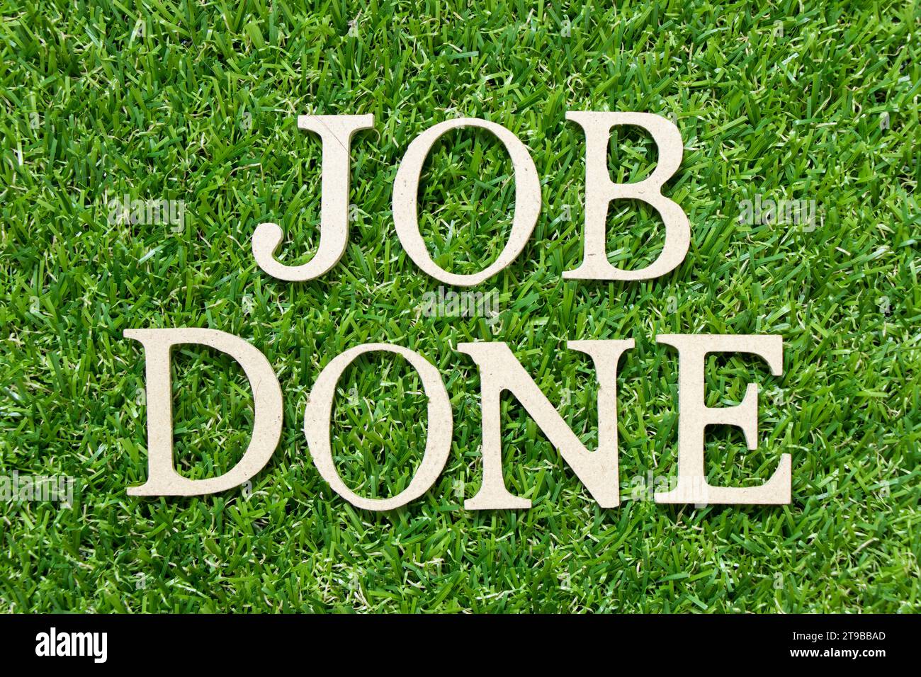 Wood letter in word job done on green grass background Stock Photo - Alamy