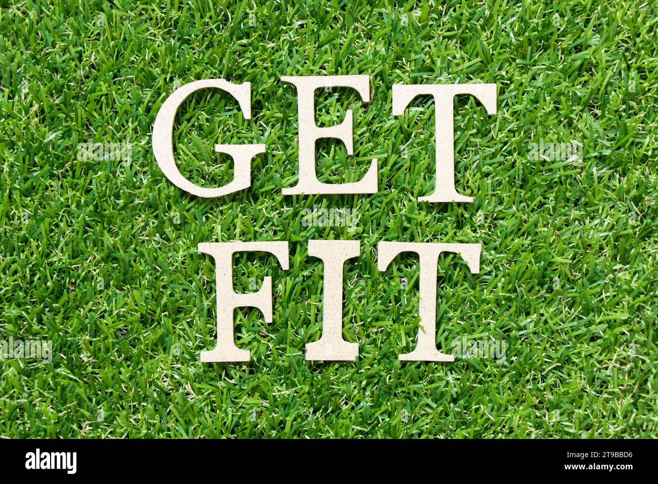 Wood letter in word get fit on green grass background Stock Photo - Alamy
