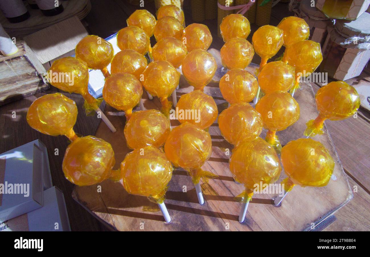 Honey lollipops displayed in a traditional market stall. Healthy candy ...