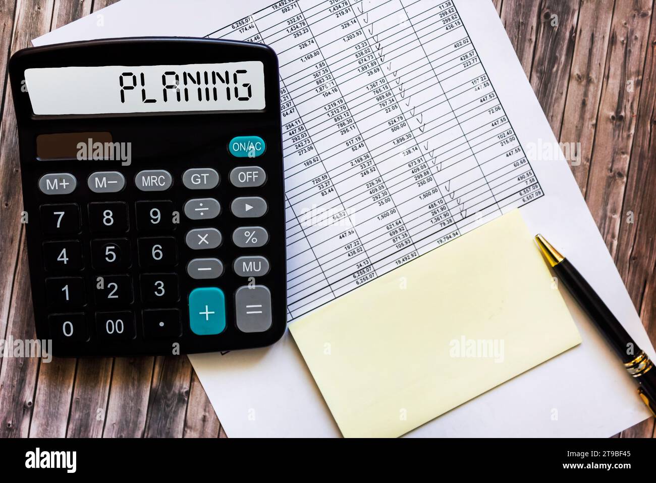 PLANNING on a calculator and on a table with papers and a notepad ...