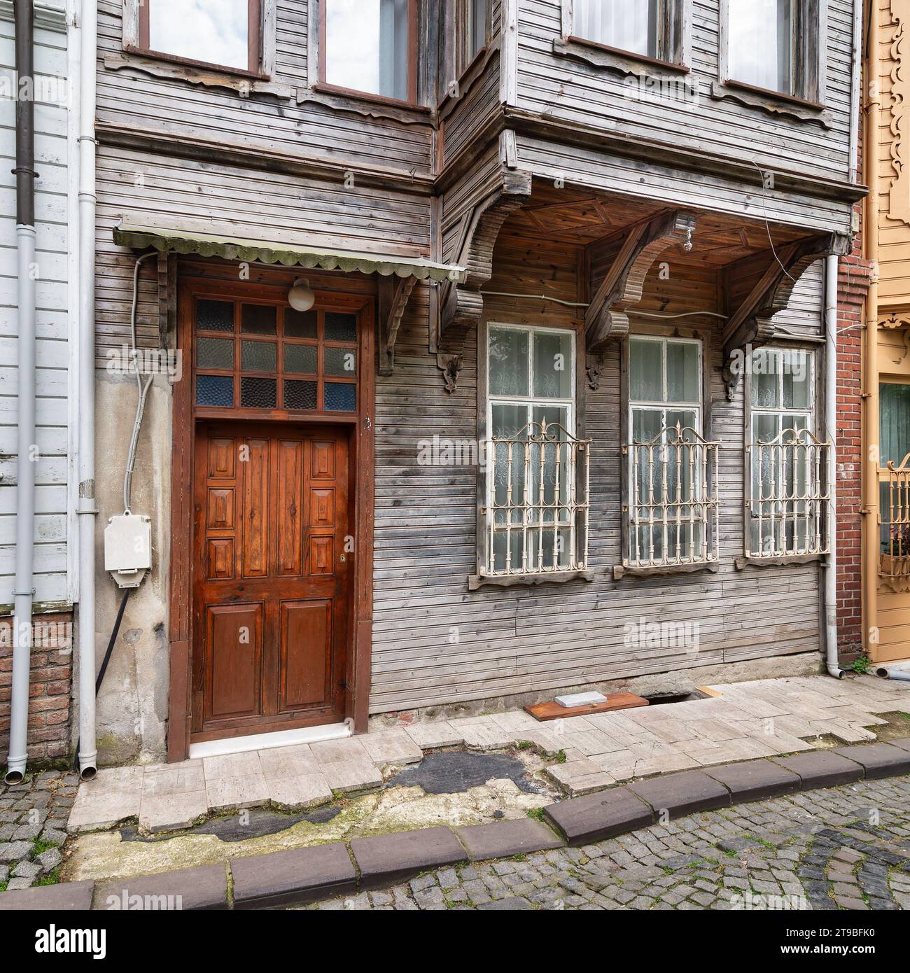 Charming wooden house with wooden decorated door and ornate wrought ...