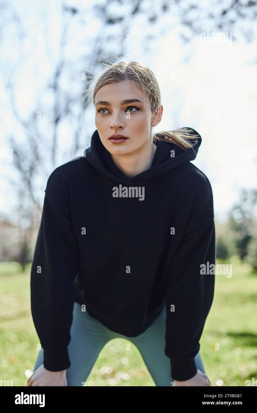 fit young woman with blonde hair and active wear working out in green ...