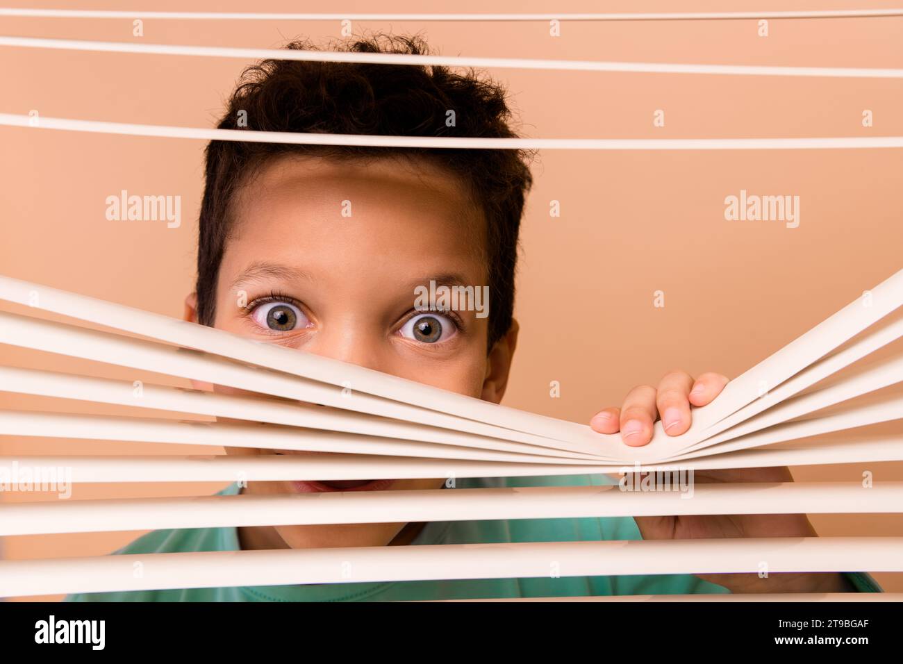 Portrait of schoolchild open look through window shutter jalousie ...