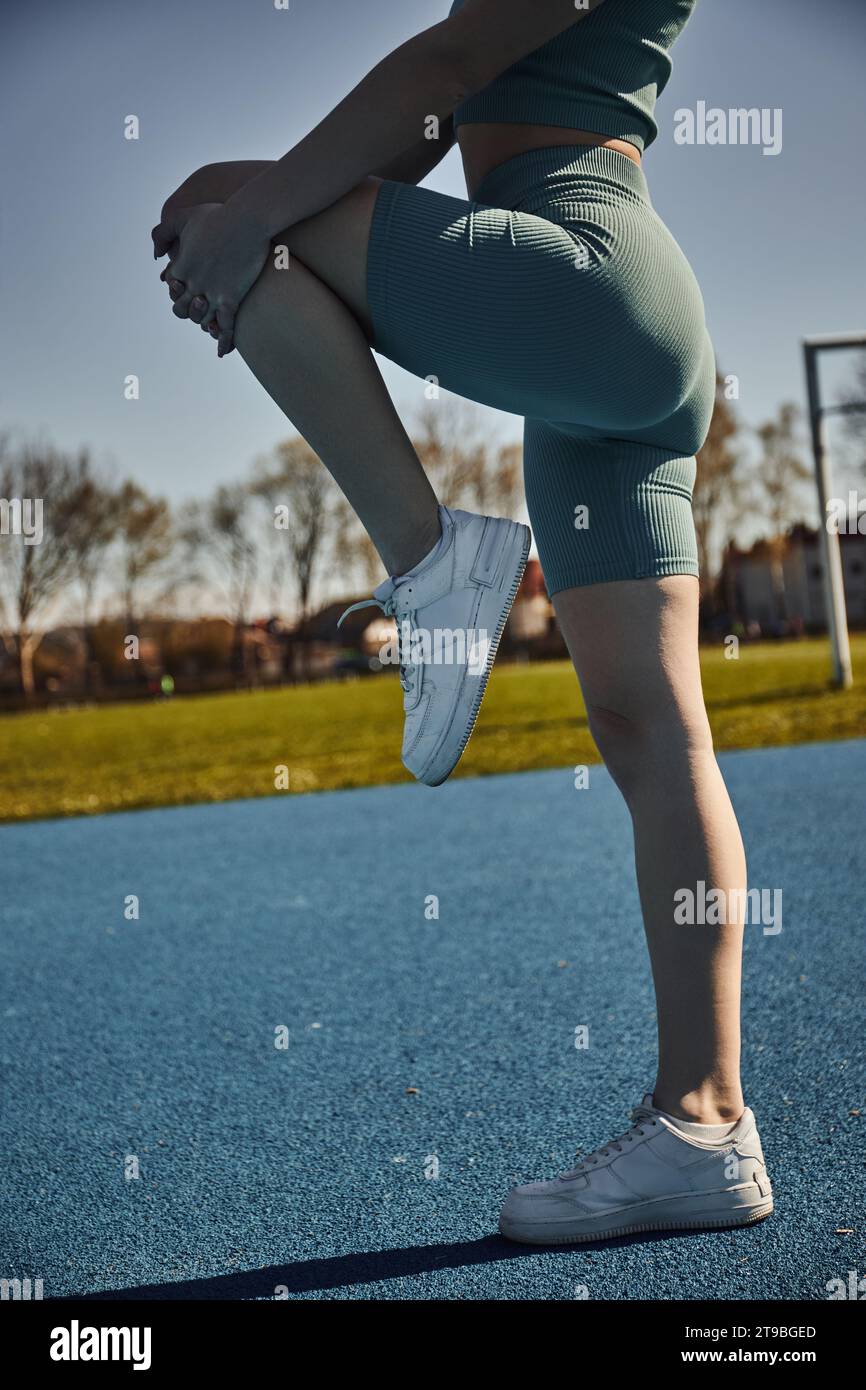 partial view of flexible sportswoman exercising in tight activewear ...