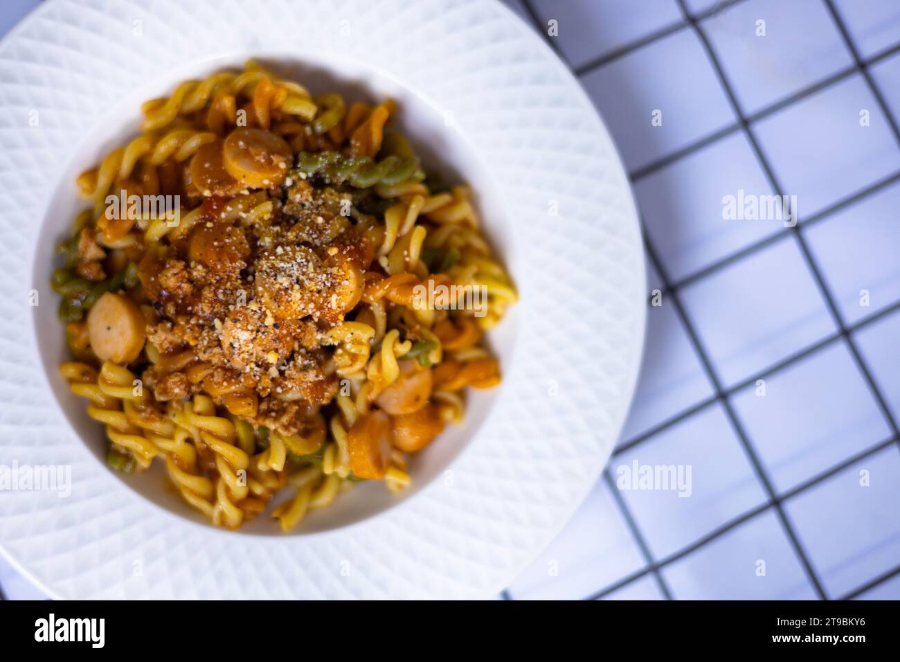 Fusilli Pasta With Sausage And Tomatoes Sauce in white dish. spiral or ...