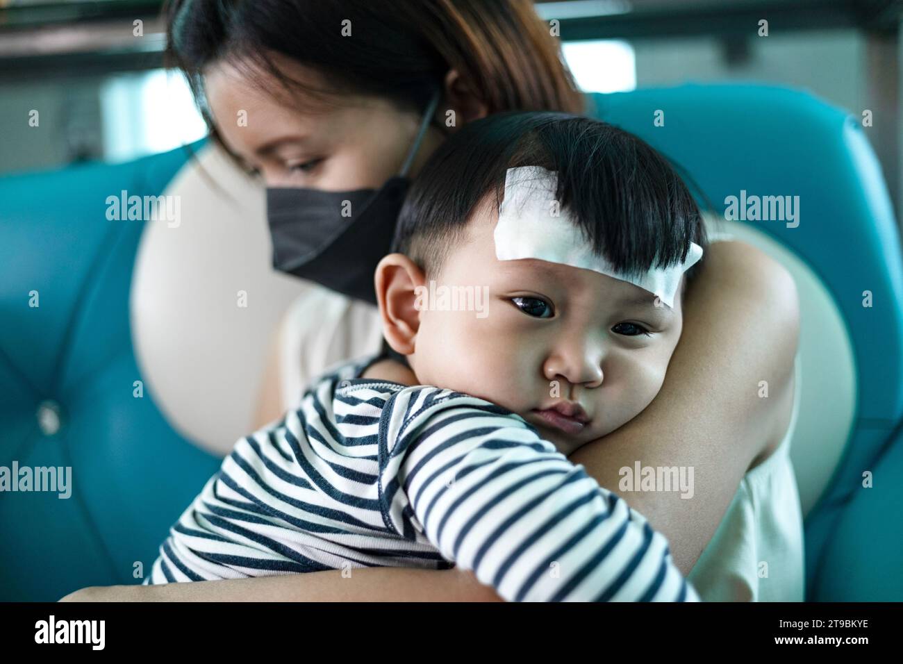 Mother attach cooling fever patch gel for reduce temperature her son. A ...